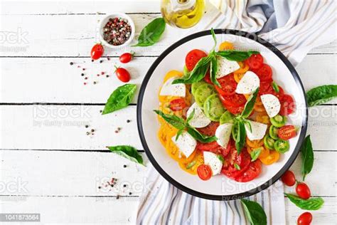 모 짜 렐 라 치즈 토마토와 바 질 허브 흰색 나무 테이블에 접시에 단풍 Caprese 샐러드입니다 이탈리아 음식입니다 상위 뷰