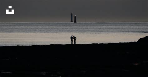 바다 옆 해변 꼭대기에 서 있는 두 사람 사진 Unsplash의 무료 라 로셸 이미지