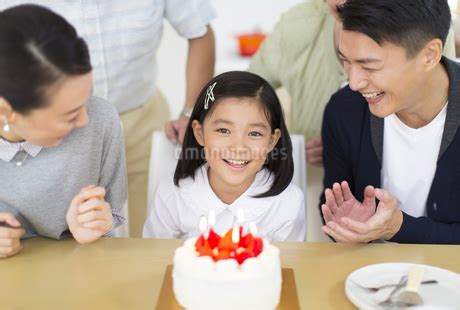 ケーキを前に誕生日のお祝いをする家族の写真素材 Fyi02967513 ストックフォトの Qlean Market