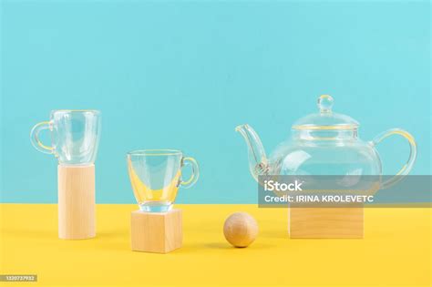 빈 유리 투명 차 세트 주전자와 나무 기하학적 모양에 서 두 컵 노란색과 파란색 배경 전면 보기입니다 유리잔에 대한 스톡 사진