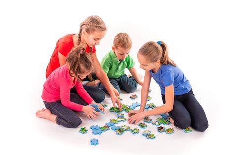 Niños de diferentes edades resolviendo rompecabezas juntos trabajo en