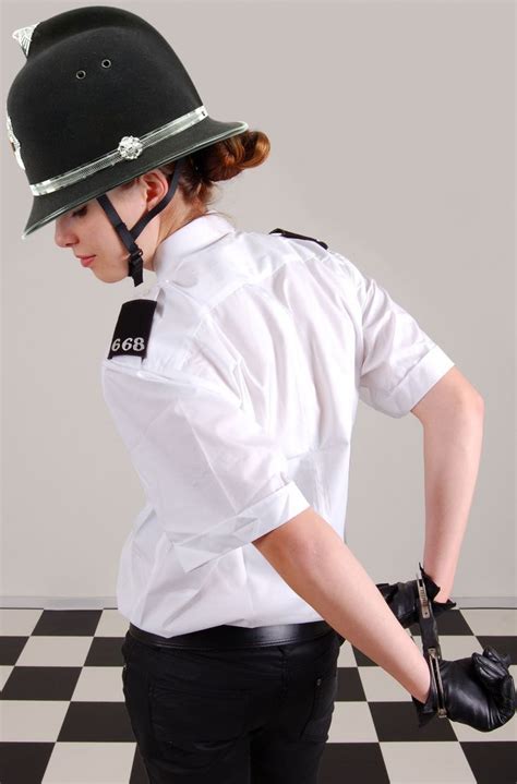 A Woman Wearing A White Shirt And Black Pants With A Motorcycle Helmet On Her Head