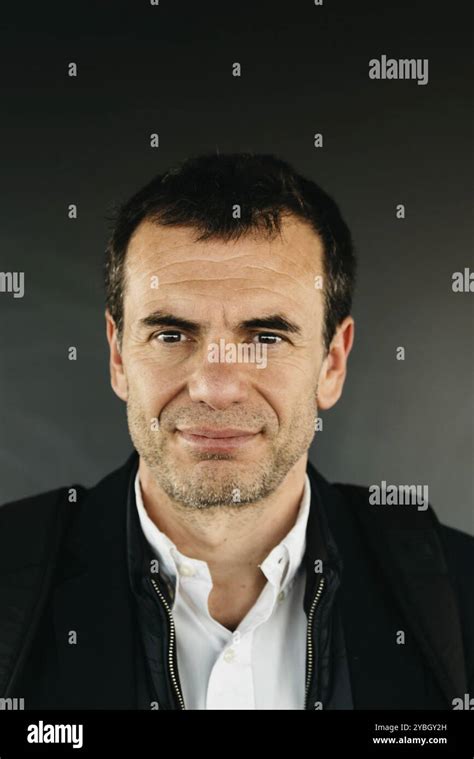 Portrait Of Middle Aged Unshaved Man Smiling Against Dark Background