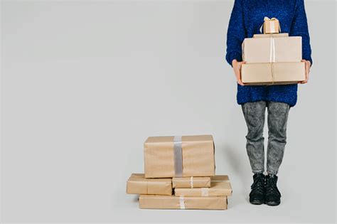 메리 크리스마스 카드 휴 년 크리스마스 생일 배너 회색 중립 배경에 리본과 많은 공예 선물 상자를 들고 파란색 스웨터에 여자 12월에 대한 스톡 사진 및 기타 이미지