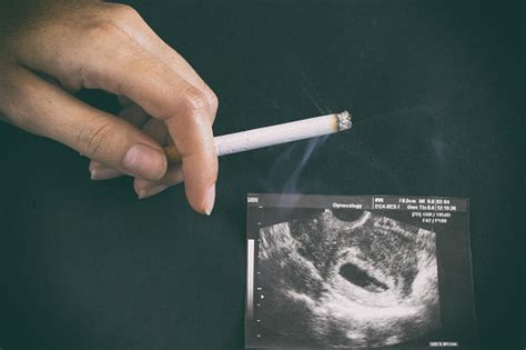 여자의 손은 임신 임신과 흡연 임신의 우지의 사진의 배경에 불타는 담배를 들고 임신에 대한 스톡 사진 및 기타 이미지 임신