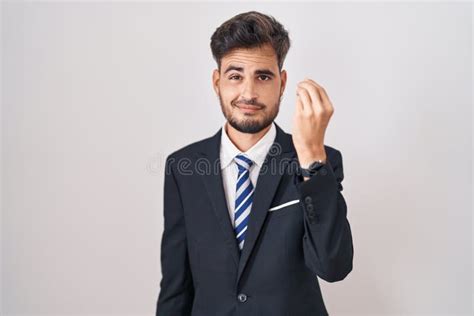 Young Hispanic Man With Tattoos Wearing Business Suit And Tie Doing