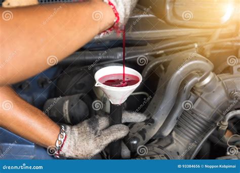 Mechanic Replacing And Pouring New Fresh Oil Into Car Engine At Stock