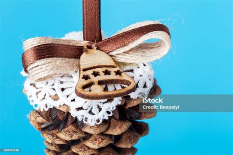 갈색 공예 리본 활과 나무 종 크리스마스 트리 장난감소나무 콘 장식 푸른 배경에 고립 된 새해 휴일에 대한 장식 개체 매달려 선물을 닫습니다 아무도 0명에 대한 스톡 사진