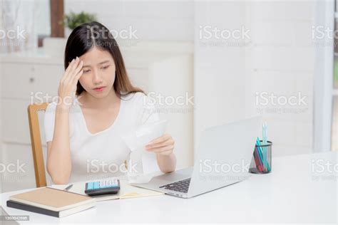 젊은 아시아 여성은 금융에 대한 비용을 계산하고 집에서 책상에 좌절 스트레스와 걱정 부채와 세금 표현과 감정 비즈니스 개념을 가지고 법안을 확인하는 소녀 지폐에 대한 스톡