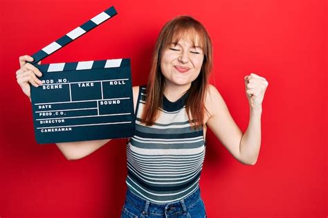 Jovem Ruiva Segurando Ripa De Filme De Vídeo Gritando Orgulhoso