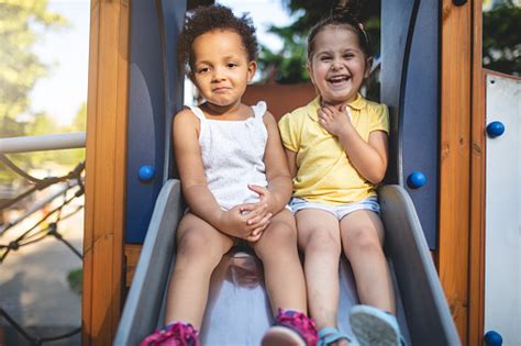 아름 답 고 귀여운 어린 아이 놀이터 슬라이드에 앉아서 웃 고 두 명의 자녀를 둔 가족에 대한 스톡 사진 및 기타 이미지 두 명의 자녀를 둔 가족 공원 놀기 Istock