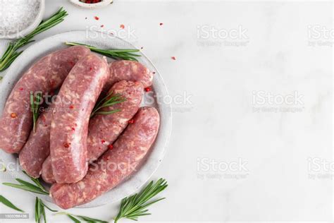 그릴이나 바베큐 음식을 요리하기 위해 향신료와 로즈마리를 곁들인 생 돼지 고기 소시지 또는 소세지 상위 뷰 소시지에 대한 스톡