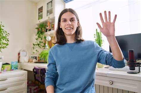 Premium Photo Handsome Teenage Male Waving Hand Looking At Webcam