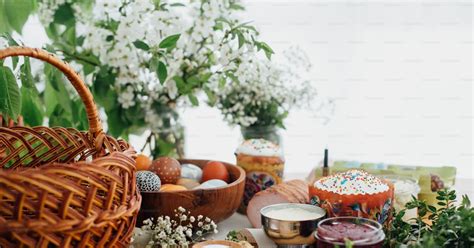 부활절 달걀 천연 염색 부활절 빵 햄 사탕무 버터 녹색 가지 고리 버들 바구니와 촛불이 있는 소박한 나무 테이블에 꽃 교회에서 축복을위한 전통 부활절 음식 사진