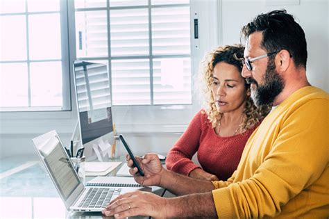 데스크톱에 집과 두 개의 Pc 노트북 컴퓨터를 사용하여 성인 커플과 가정 무료 사무실 라이프 스타일에서 스마트 작업 현대 남자와