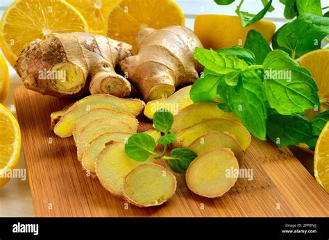 Lemons Ginger And Mint Leaves Lemon Halves Slices Of Ginger And Mint Leaves On A Wooden Board