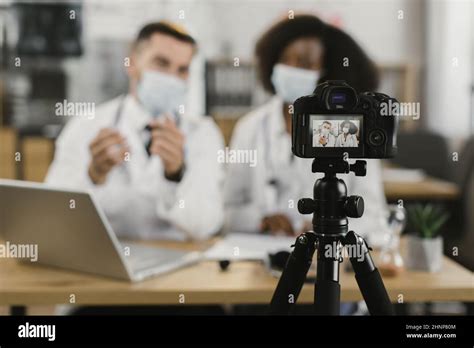 Multi Ethnic Medical Specialists In Face Mask Using Professional Camera