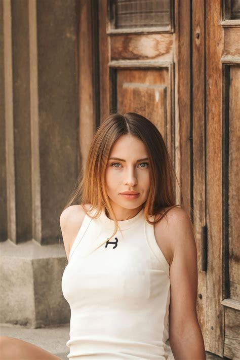 Smiling Woman In White Tank Top And Blue Denim Jeans Sitting On Chair