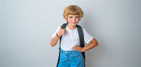 엄지손가락을 치켜들고 배낭을 메고 카메라를 바라보는 초등학교 소년 소녀 빈 개념을 광고하기 위한 공간을 복사합니다 학교로 돌아 가기 어린 시절 교육 어린이를위한 제품 6 7