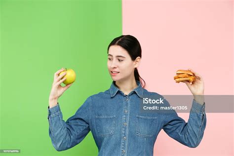 다이어트입니다 다이어트 개념입니다 건강 한 음식입니다 아름 다운 젊은 여자 사이 과일과 Unhelathy 패스트 푸드 선택