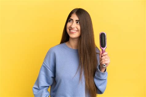 Premium Photo Young Caucasian Woman Holding Hairbrush Isolated On