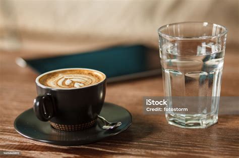 라떼 아트와 물 한 잔이 담긴 카푸치노 컵이 테이블 위에 제공됩니다 0명에 대한 스톡 사진 및 기타 이미지 0명 개념 기업 재무와 산업 Istock