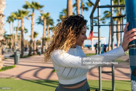 Young Blonde Woman With Curly Hair Stretching To Do A Sports Routine