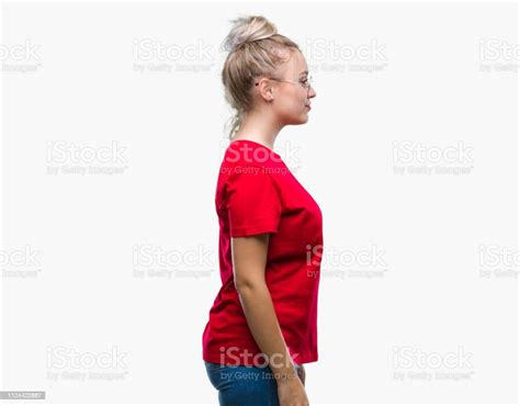 사이드로 보고 격리 된 배경 위에 젊은 금발 여자 입고 안경 긴장 자신감 미소와 자연 스러운 얼굴 프로필 포즈 금발 머리에 대한