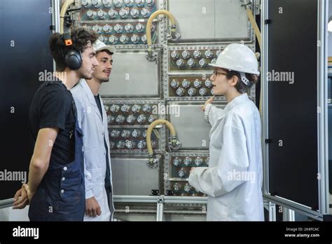 Scientist Discussing Over Quality Control With Colleagues In Factory