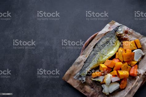 송어는 야채 호박과 양파와 향신료에 전체 구운 나무 판에 베이킹 종이에 검은 배경 복사 공간 굽기에 대한 스톡 사진 및 기타