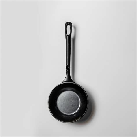 Premium Photo A Black Cast Iron Frying Pan Hangs On A White Background