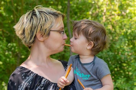 Mom And Son Eat Salted Sticks Together In Nature Love Between Mother