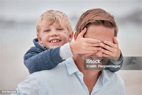 가족 얼굴 아버지와 아들이 해변에서 놀람 추측 및 게임을 위해 아빠의 눈을 손으로 가리고 있습니다 여행 행복한 가족과 아이는