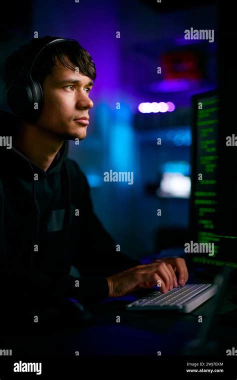 low key lighting shot of male computer hacker sitting in front of