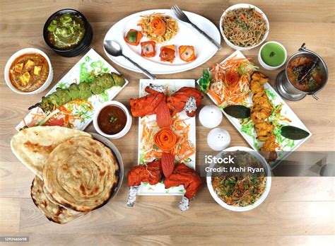 나무 배경에 다양한 인도 음식 탄두리 치킨 파네어 버터 마살라 치킨 비리야니 파네어 티카 치킨 티카 파라타 인도 요리의 요리와 전채 Paneer Tikka에 대한 스톡 사진