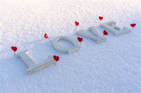 고립 된 단어의 근접 촬영 사랑 눈 속에서 나무 조각에서 레드 심장 장식 주위 흰색 배경으로 맑은 겨울 날에개념의 사랑 행복과 기쁨 발렌타인 데이에 감정에 대한 스톡 사진