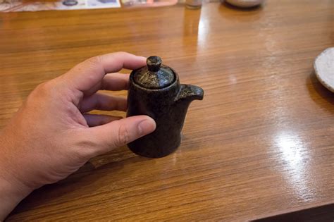 손을 뚜껑 나무 테이블에 고립 된 일본 간장 세라믹 주전자를 들고 간장에 대한 스톡 사진 및 기타 이미지 간장 갈색 개념 Istock