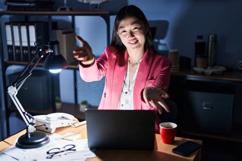 Chinese Young Woman Working At The Office At Night Looking At The