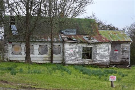 An Old Abandoned And Dilapidated House With Rusted Green Tin Roof Stock