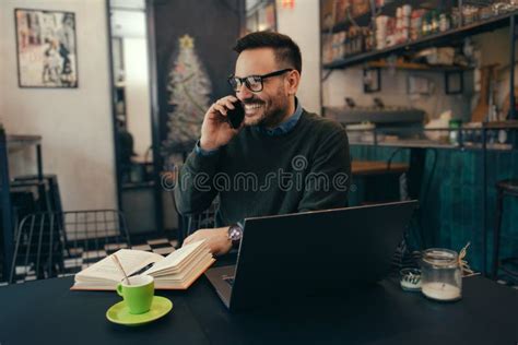 Smiling Businessman In Eyeglasses Using Laptop And Talking On Phone In