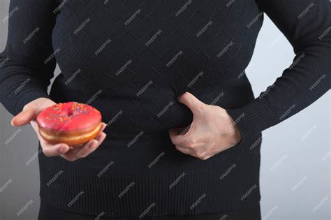 뚱뚱한 여자 손 도넛 프리미엄 사진