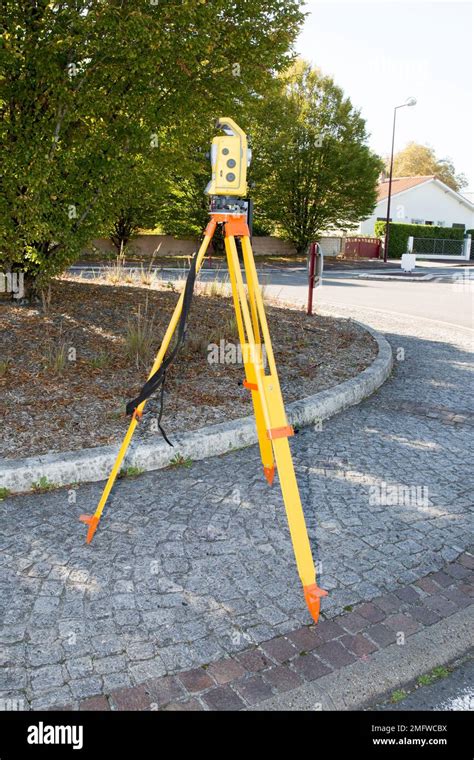 Surveyor At Work With An Infrared Reflector Used For Distance Measurement On Roadside Land
