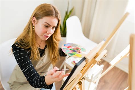 밝은 아트 스튜디오에서 팔레트와 브러시를 사용하여 캔버스에 그림을 그리며 예술에 대한 창의성과 열정을 표현하는 여성 예술가 공예에 대한 스톡 사진 및 기타 이미지 Istock
