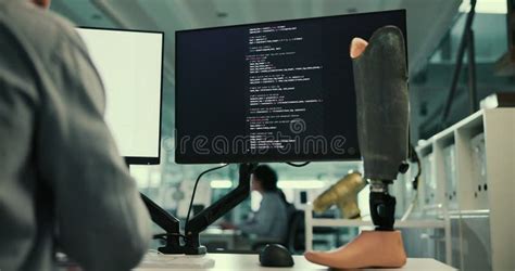 Robotics Development And Person At Computer Screen With Prosthetic Leg