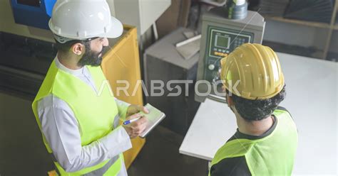 مهندسان سعوديان عاملان يشرفان في داخل المصنع في المملكة العربية