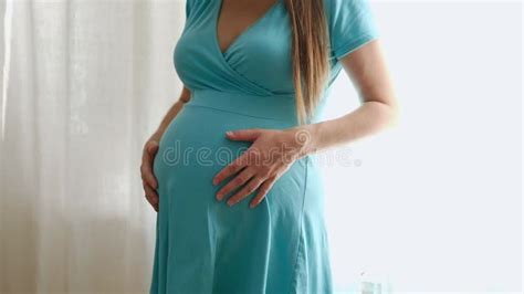Young Pregnant Woman In A Blue Dress Strokes Her Big Belly Stock Video