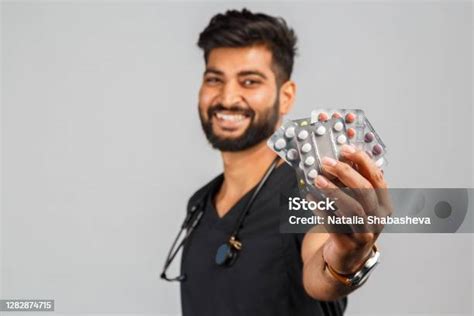 회색 배경에 청진기와 알약과 젊은 인도 의사 또는 외과 의사를 즐겁게 건강관리와 의술에 대한 스톡 사진 및 기타 이미지 건강관리와 의술 구급대원 남자 Istock