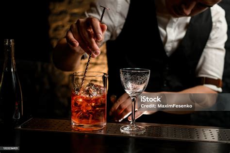 特寫調酒師的手拿著長勺子 將飲料混合在玻璃混合杯中 用冰塊 照片檔及更多 不銹鋼 照片 不銹鋼 人 人手 Istock