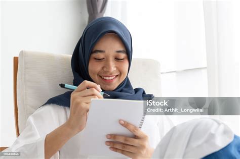 젊은 무슬림 여성 학생들은 창조적 인 프리랜서 기자 앉아 히잡 소녀 이슬람 종교 아시아 민족 즐거운 인터넷 뱅킹 태블릿 모바일 스마트 폰에 대한 기업가 직업 개념으로 쓰기