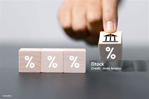 주택 및 부동산 투자 및 자산 관리 개념입니다 이자율 대출 모기지 주택세 퍼센트 아이콘이 있는 스택에서 나무 블록에 집 아이콘을 들고 있는 손 텍스트를 위한 공간을